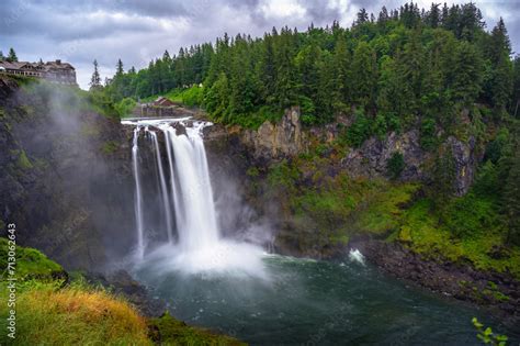 Snoqualmie Falls With Lush Greenery And Mist In Washington State Usa