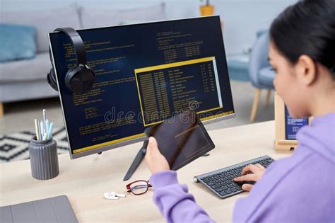 Female Computer Programmer Writing Code For Mobile Devices At Desk