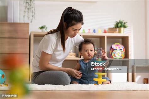 아시아 엄마는 가정이나 보육실에서 발달 기술을 위해 아기 소년을 배우고 장난감을 가르칩니다 행복한 엄마와 아기가 따뜻한 곳에서 함께 시간을 보낸다 엄마와 아기와 함께 좋은
