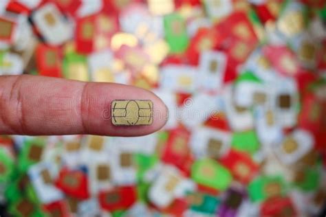 The Gold Phone Sim Card Chip Placed On The Young Man`s Finger Is A Sim