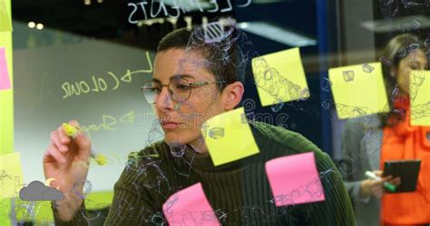 Image Of Connected Dots Forming Abstract Shape Over Caucasian Woman Writing On Glass Wall Stock