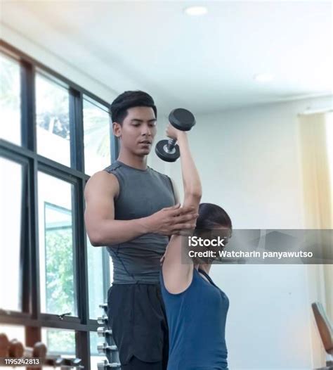 피트니스 센터에서 아령 운동 프로그램 사용 아령에 대한 아름다운 여성을 가르치는 트레이너 남자에 대한 스톡 사진 및 기타 이미지