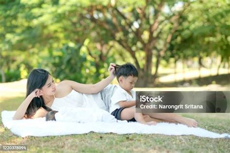 젊은 아시아 의 어머니 휴식 에 거짓말 에 화이트 카펫 근처 그녀의 작은 아기 과 그녀의 아들 누구 즐기는 와 휴대 전화 와 인터넷 가족에 대한 스톡 사진 및 기타 이미지