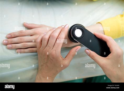 Female Dermatologist Using A Professional Dermatoscope While Doing Skin