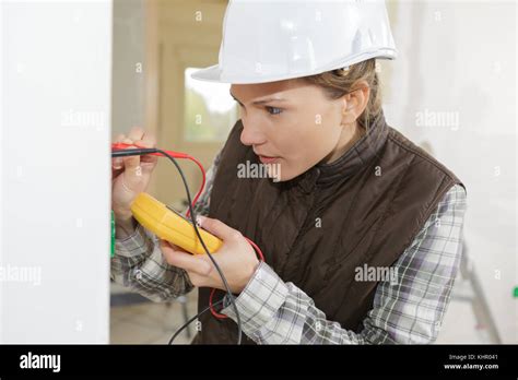 Female Electrician Testing A Wall Socket Stock Photo Alamy