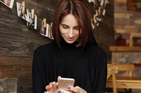 Toujours En Contact Jolie Jeune Femme Moderne Avec Des Cheveux En Chocolat Ditant Des Photos