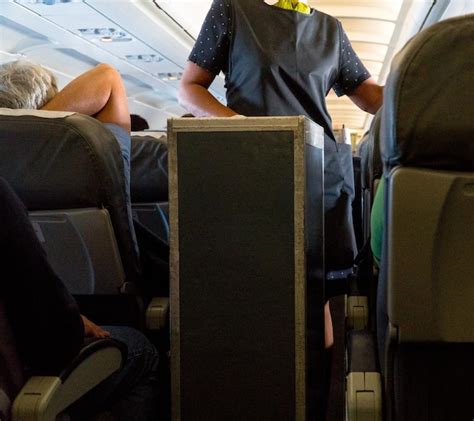 Premium Photo Angle Shot Of A Stewardess Passing Something To Passengers