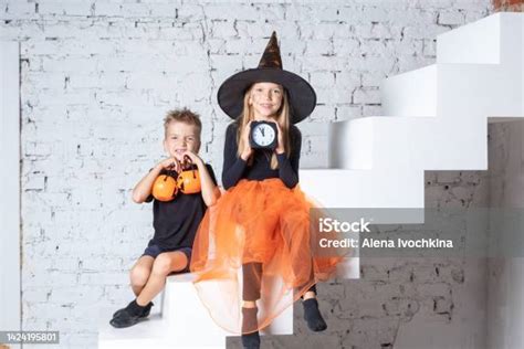소름 끼치는 마녀 의상과 모자를 쓴 아이들은 검은 색 알람 시계와 호박 모양의 바구니를 들고 있습니다 10월에 대한 스톡 사진 및 기타 이미지 Istock