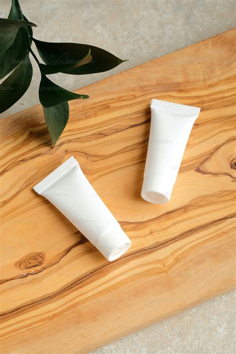 나무 보드에 화장품 로션과 녹색 잎으로 튜브 포장 흰색 빈 화장품 크림 용기 디자인 브랜딩 사진 Unsplash의 포장 이미지