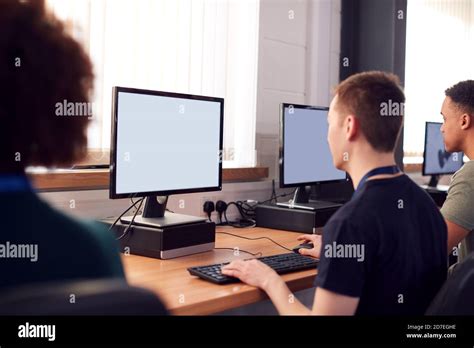 Group Of College Babes Studying Computer Design Sitting At Line Of Monitors In Classroom