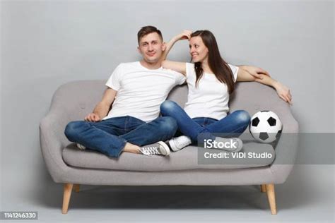 흰색 T 셔츠에 아름 다운 커플 여자 남자 축구 팬 응원 축구 공 회색 배경에 고립 된 포옹과 좋아하는 팀 지원 사람들의 감정