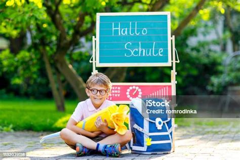 책상 및 배낭 또는 가방에 앉아 안경을 가진 행복 한 작은 아이 소년 학교에 그의 첫번째 날에 슐츠에 게 불린 전통적인 독일 학교 부 대 콘을 가진 학교 아이 개념에 대한