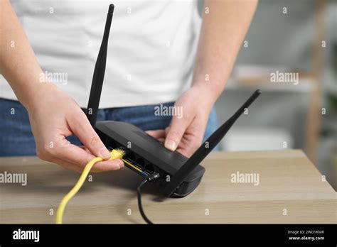 Woman Inserting Ethernet Cable Into Wi Fi Router At Table Indoors Closeup Stock Photo Alamy