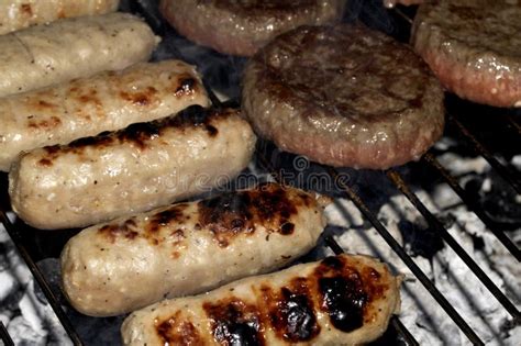Close Up of BBQ Open Air Cooking with Burgers and Hot Dog Sausages Being Cooked on the Grill ...