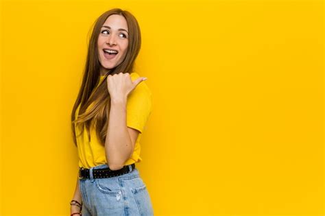 Premium Photo Young Ginger Redhead Woman Points With Thumb Finger