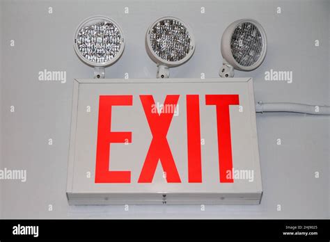 The Flashing Red Security Exit Sign With Three Powerful Lights On The Exit Of A Building Stock