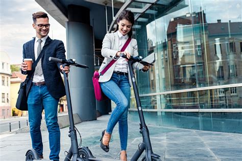 현대 비즈니스 빌딩 앞에서 전기 스쿠터를 운전하는 두 명의 웃는 사업가가 일하고 있습니다 2명에 대한 스톡 사진 및 기타 이미지 2명 30 39세 거리 Istock