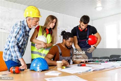 한 고위 건설 노동자가 젊은 동료들과 함께 프로젝트 계획을 분석하고 있습니다 20 24세에 대한 스톡 사진 및 기타 이미지 20 24세 25 29세 30 34세