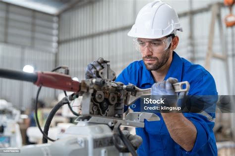 공장에서 렌치 공구 수리 로봇 팔 용접기를 사용하는 남성 엔지니어 로봇 산업에서 일하는 유니폼을 입은 기술자 자동화 로봇 산업에