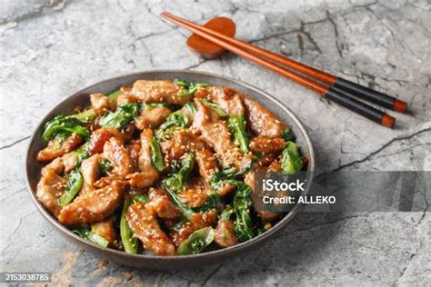 얇게 썬 돼지고기 안심과 로메인 상추 참깨 마늘을 간장에 담아 접시에 담아 볶은 중국식 요리 가로 중국 요리에 대한 스톡 사진