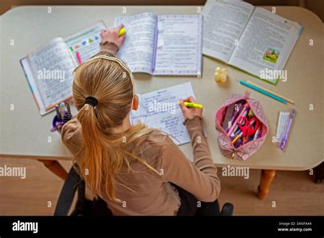 Schoolgirl Highlighting Notes While Studying A Girl At A Desk