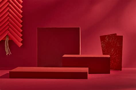 중국 설날 디자인은 진홍색 배경에 놓인 몇 개의 빨간색 플랫폼을 클로즈업하여 제품 진열을위한 빈 공간을 만들고 빨간색 행운의 봉투와 빨간색 폭죽으로 장식합니다 0명에 대한