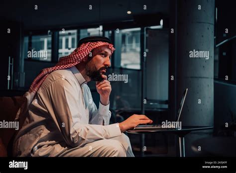 An Elderly Arab Man Sitting In The Office And Analyzes Data On His