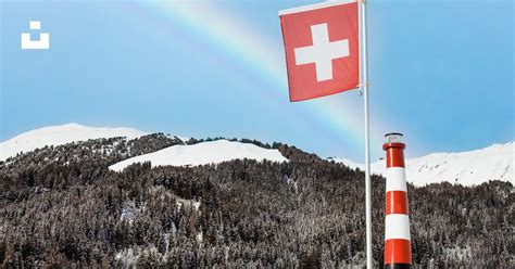 산 꼭대기에 빨간색과 흰색 십자가 깃발 사진 Unsplash의 무료 스위스 이미지