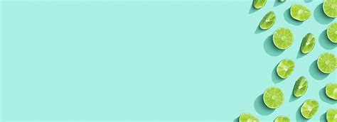 감귤류 라임 과일은 창의적인 와이드 배너로 복사 공간이있는 파스텔 민트 배경의 햇빛에 하드 그림자가있는 녹색 라임 조각 과일