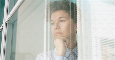 흰 코트를 입은 젊은 여성 과학자 또는 연구원이 과학 실험실 내부 창가에 서서 턱을 잡고 있다 사진 Unsplash의 사람 이미지