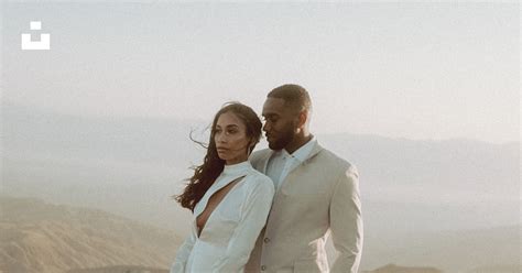 낮에 바위에 흰 드레스를 입은 여자 옆에 서 있는 흰 양복을 입은 남자 사진 Unsplash의 무료 결혼식 이미지