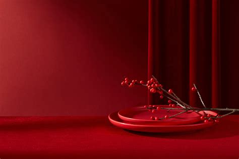 같은 색의 고급 커튼이 있는 빨간색 배경 위에 빨간 테이블을 클로즈업 샷 위에 빨간 꽃 가지가 있는 빨간 접시 더미 텍스트 복사 공간 앞면 보기 0명에 대한 스톡 사진 및
