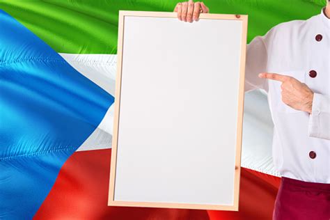 적도 기니 국기 배경에 빈 화이트 보드 메뉴를 들고 요리사 텍스트에 대 한 균일 한 포인팅 공간을 착용 요리 고급 요리에 대한 스톡 사진 및 기타 이미지 Istock