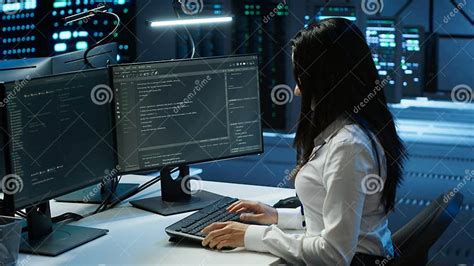 Engineer In Data Center Sitting Down At Desk Installing Software Stock