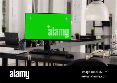 Empty Office Desk With Pc Running Greenscreen On Display Showing
