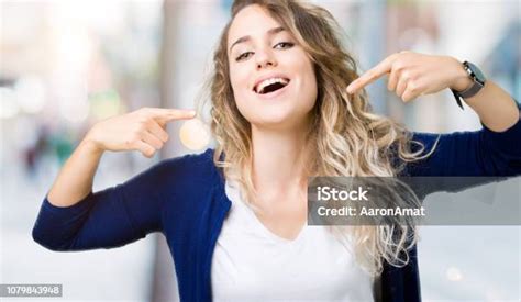 웃 고 자신감 보여주는 손가락 치아와 입 지적 고립 된 배경 위에 아름 다운 젊은 금발 여자 건강 개념입니다 가리키기에 대한 스톡 사진 및 기타 이미지 Istock