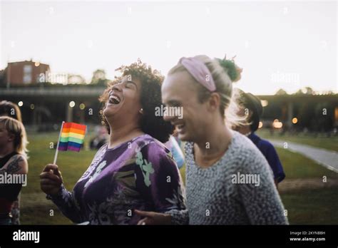 Cheerful Transgender Woman Holding Rainbow Flag While Enjoying With Non