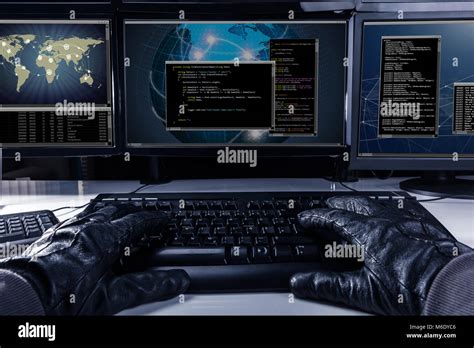 Hacker Wearing Gloves Typing Code On Keyboard In Front Of Multiple