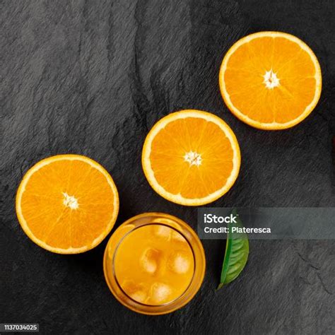 오렌지 반쪽과 녹색 잎이 있는 신선한 오렌지 주스 한 잔 텍스트를 위한 장소가 있는 검정색 배경의 상단에서 촬영 0명에 대한 스톡 사진 및 기타 이미지 Istock