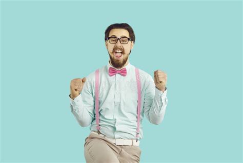 Cheerful Happy Male Hipster Nerd Rejoices In His Success Standing On Light Blue Background