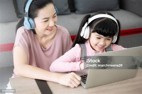 부모 온라인 학습 연구 온라인 수업 화상 통화 교사와 아시아 여자 학생 아이와 엄마 착용 헤드셋 과 사용 노트북 에 집에서 2명에 대한 스톡 사진 및 기타 이미지 Istock