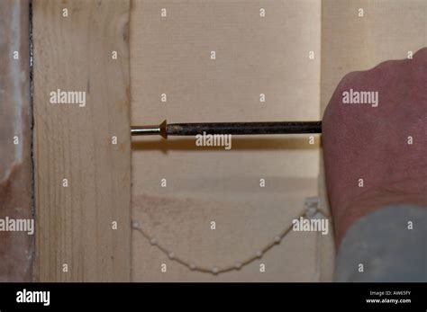 Screwing Batten To Wall Stock Photo Alamy