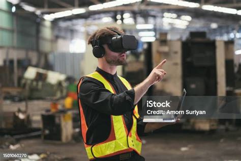 가상 현실 헤드셋을 사용하는 남성 공장 정비사 남성 엔지니어는 산업 공장에서 기계를 점검하고 안전 유니폼과 헬멧을 착용하기 위해