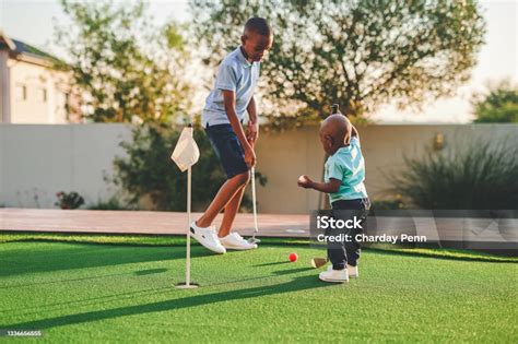 뒷마당에서 골프를 치는 두 명의 젊은 형제의 전체 길이 샷 골프에 대한 스톡 사진 및 기타 이미지 골프 아이 12 17 개월 Istock