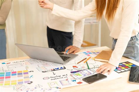 A Team Of Ui Ux Web Designers Is Working Together To Develop A Mobile Responsive Website With