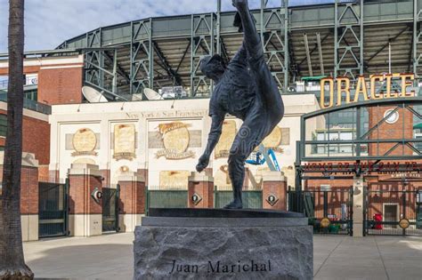 a statue of juan marichal in front of oracle park with office buildings