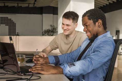 two smiling positive programmers working in the office of a software