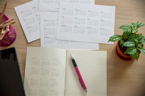 의제 플래너 책 달력 태블릿 연필 및 사무실 책상에 시계 장소 주최자가 시간표 일일 약속 및 관리 업무를 계획하는 일기 플래너 책 및 2022 달력 개념 0명에 대한 스톡