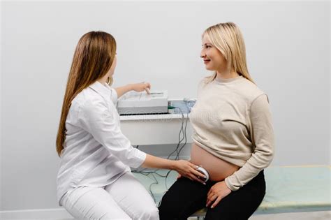 Woman Pregnant Checking Fetal Heart Beat By Fetal Monitoring Expectant Mother With Midwife
