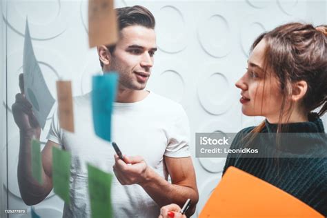 새로운 시작과 좋은 아이디어를 논의 하는 기업 들의 팀 스티커 메모와 함께 유리 벽 뒤에 사무실 공간에 서 있는 동료의 초상화 2명에 대한 스톡 사진 및 기타 이미지